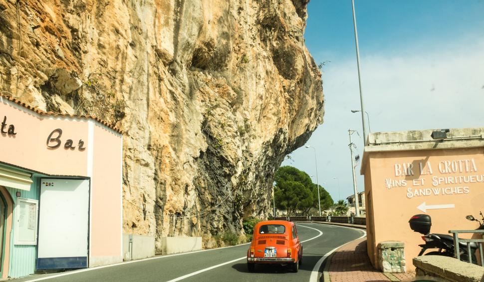 Free Stock Photo of Orange Car Driving Down Road Next to Cliff ...