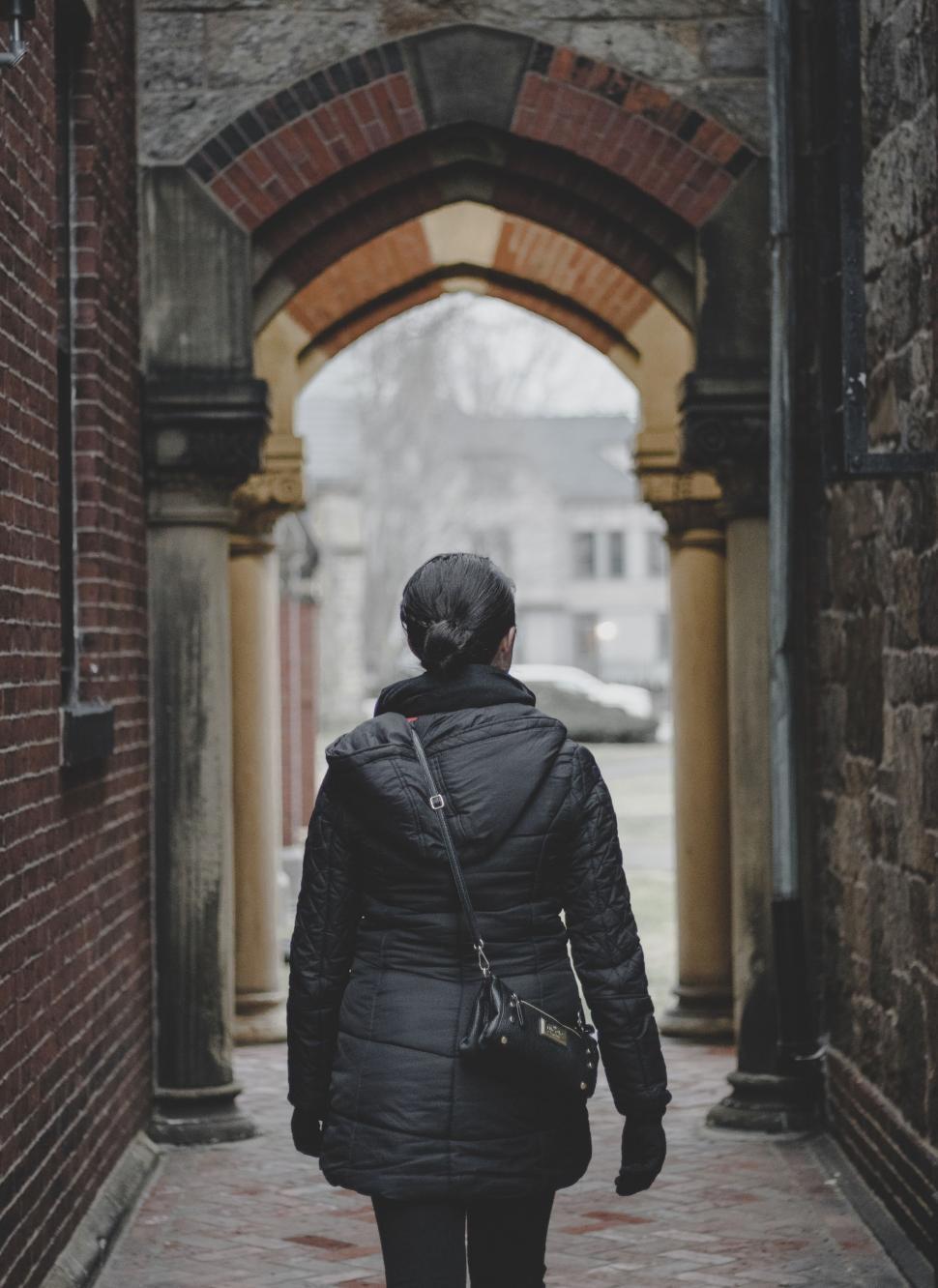 Free Stock Photo of Woman Walking Down Street Next to Brick Building ...
