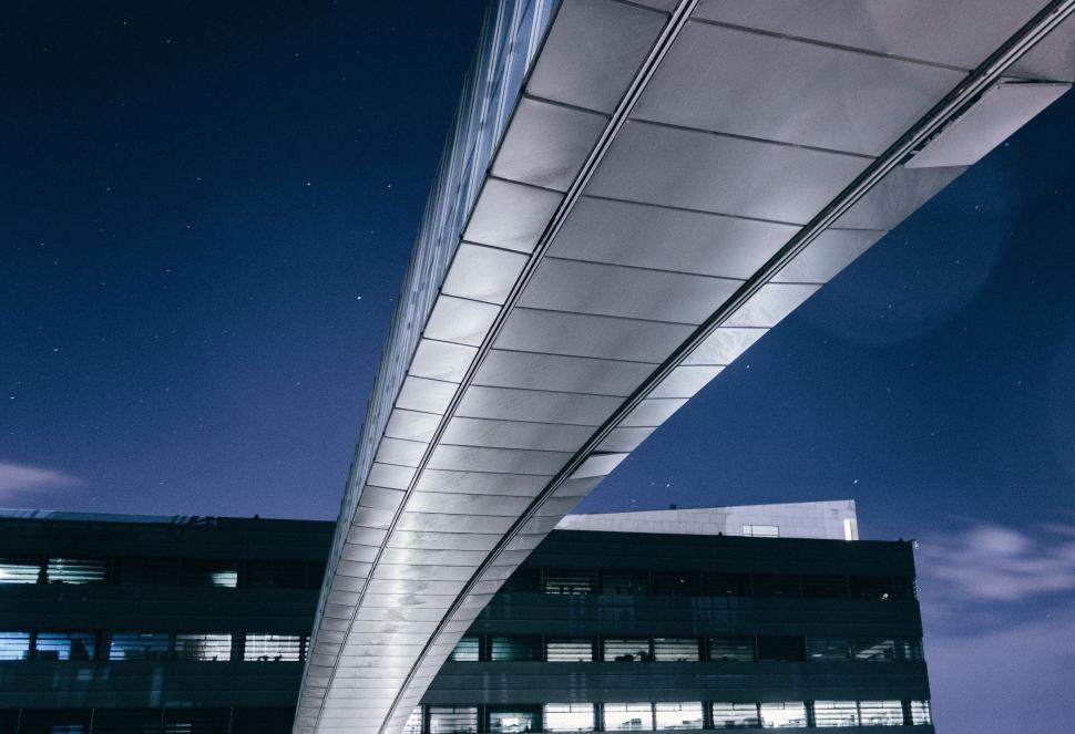 Free Stock Photo of Tall Building With Long Bridge Spanning Across ...