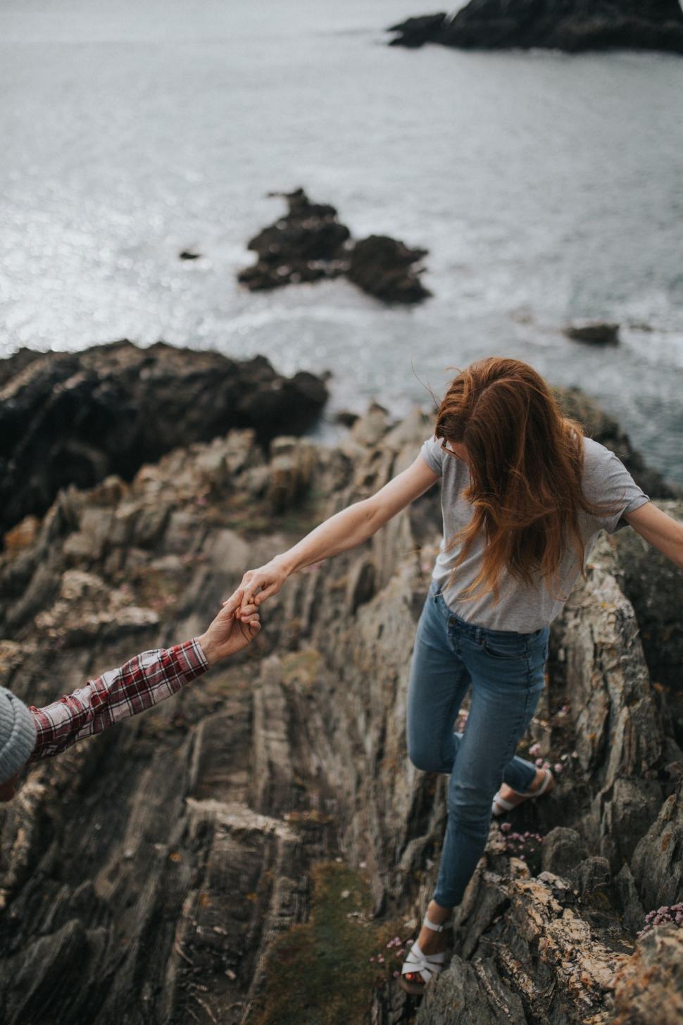 Free Stock Photo of Two People Holding Hands on a Rocky Cliff ...
