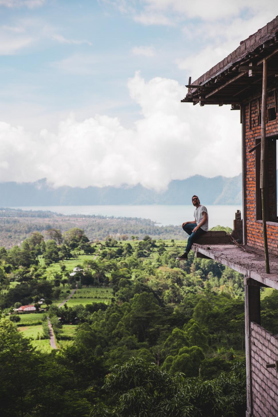 Free Stock Photo of A young Caucasian man sitting on the edge of a ...