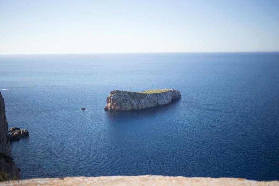 Free Stock Photo of A small rocky island surrounded by blue water ...