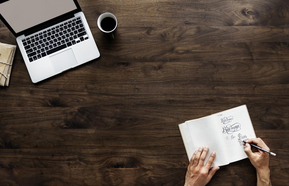 Free Stock Photo of Overhead view of hands writing on a notebook with ...