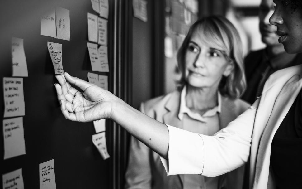 Free Stock Photo of A woman looks at sticky notes on a working board ...