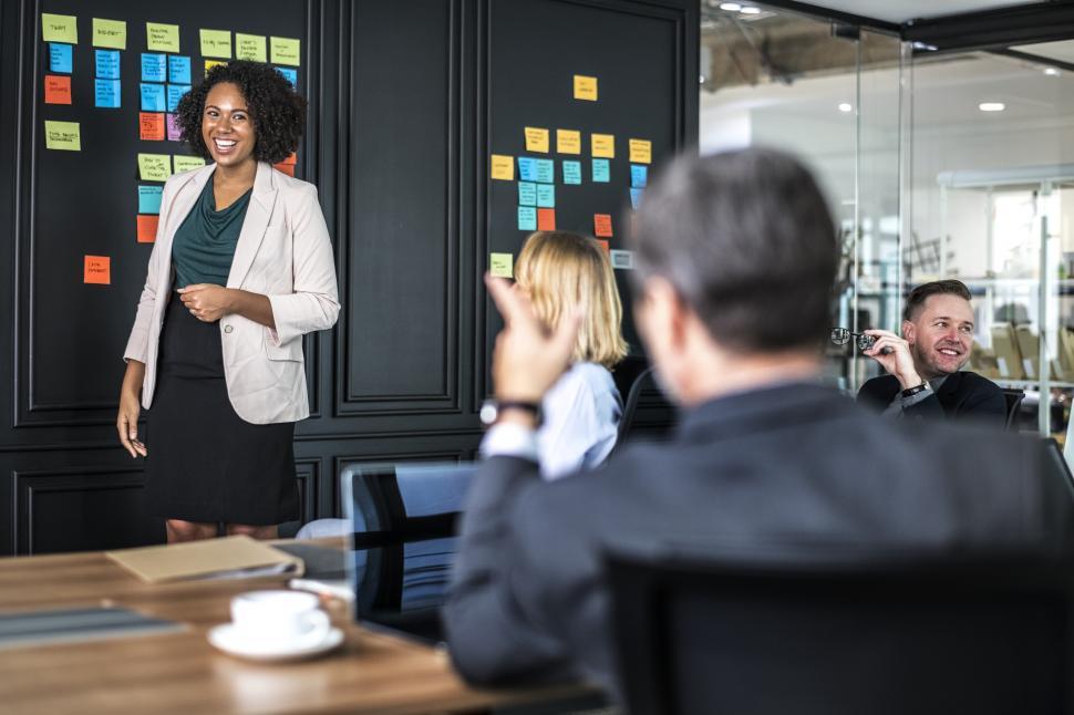 Free Stock Photo of A smiling young woman presenting in a business ...