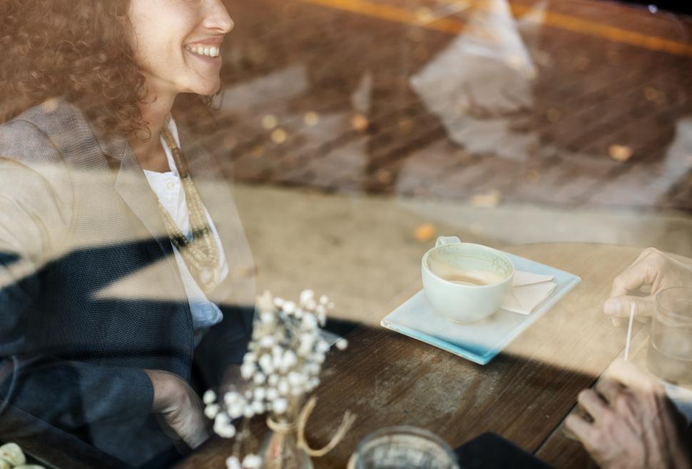 Free Stock Photo of A young woman at a cafe table seen through window ...