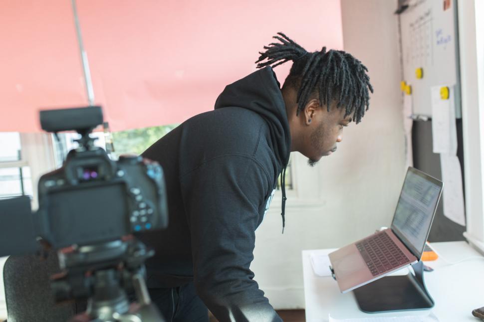 Free Stock Photo of Young Male Vlogger with laptop and camera in office ...