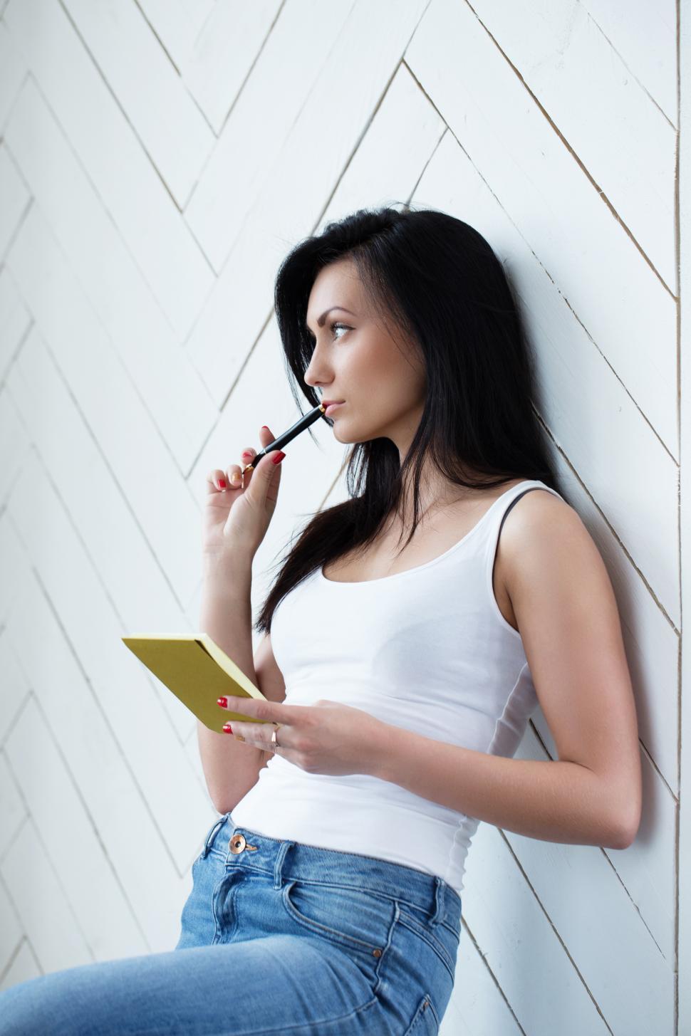 Free Stock Photo of Young woman thoughtfully chewing on her pen ...