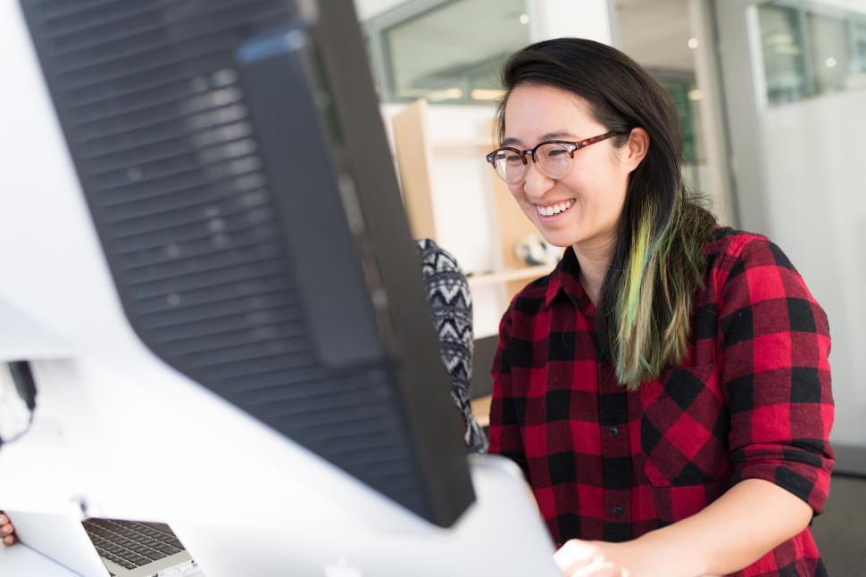 Free Stock Photo of Happy Female developer in glasses using desktop ...
