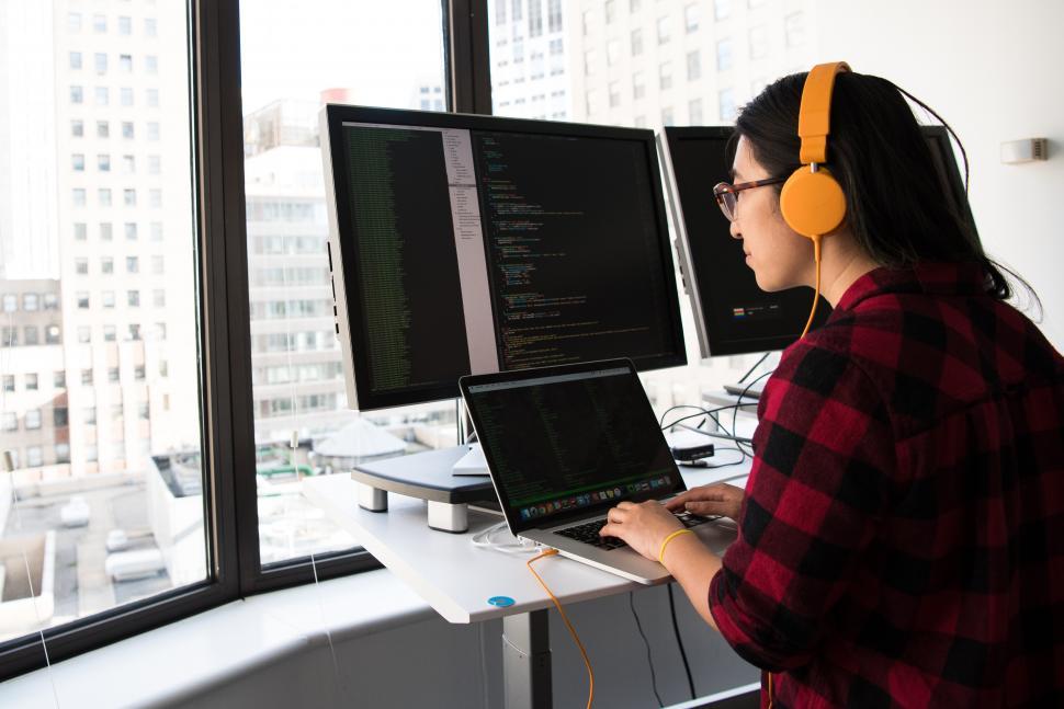 Free Stock Photo of Female developer in glasses with desktop computers ...
