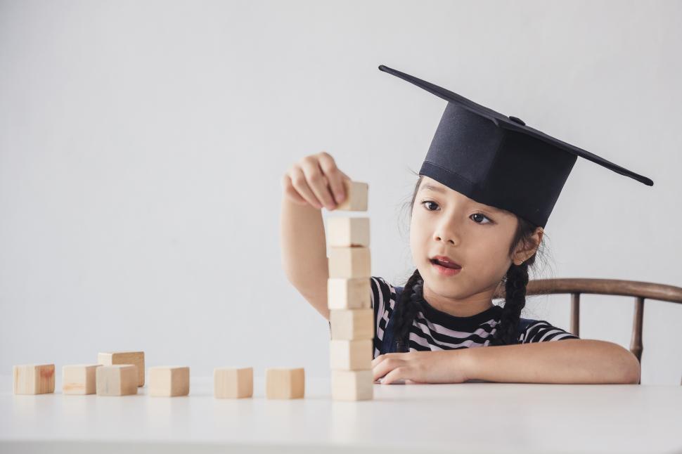 Free Stock Photo of Little girl wearing mortarboard stacking blocks ...