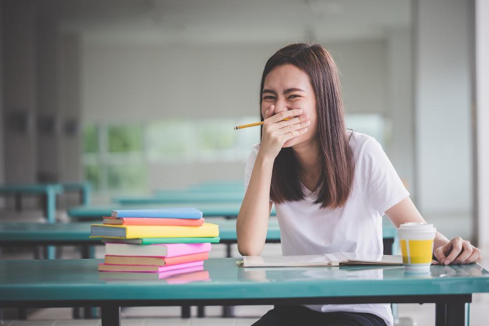 Free Stock Photo of Student stifling a laugh at her desk | Download ...