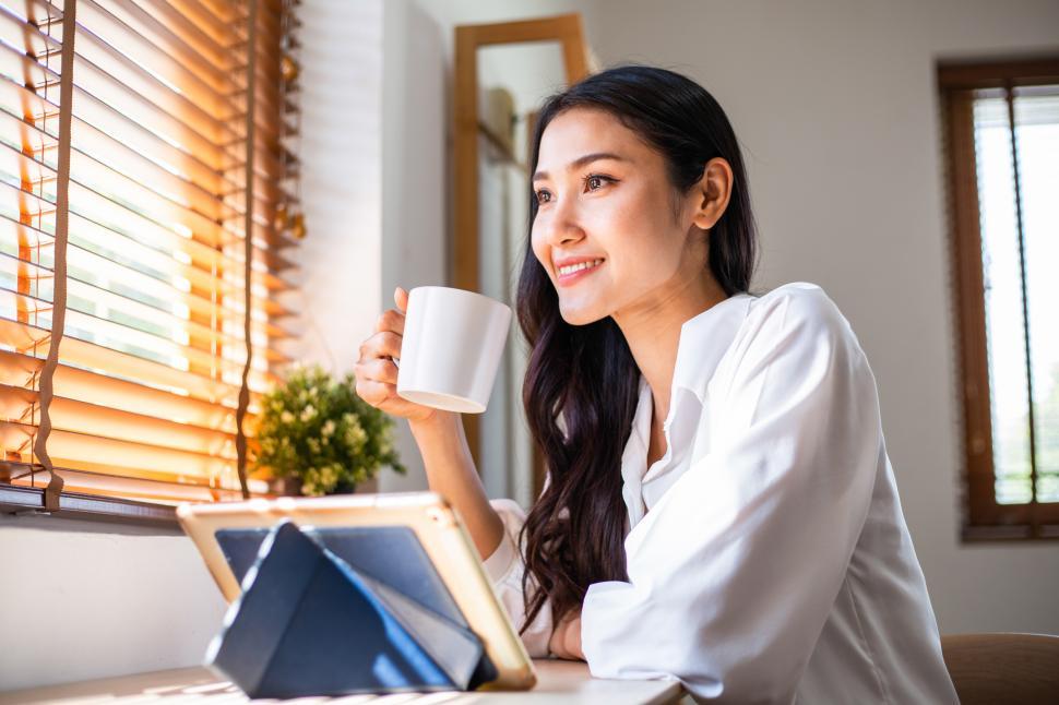Free Stock Photo of Woman drinking coffee and using digital tablet to ...