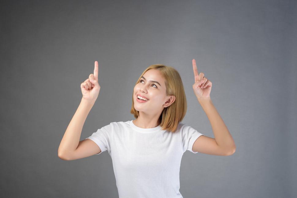Free Stock Photo of Woman pointing at blank copyspace above her head ...