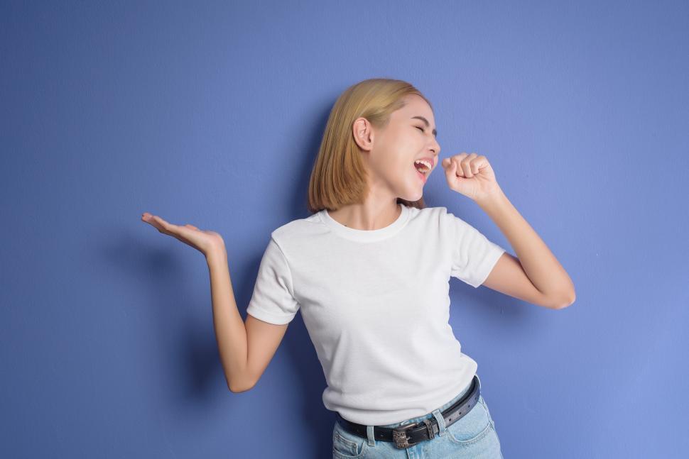 Free Stock Photo of Woman pantomimes singing performance over purple ...