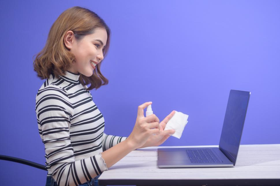 Free Stock Photo of Young woman sanitizing computer with alcohol spray ...