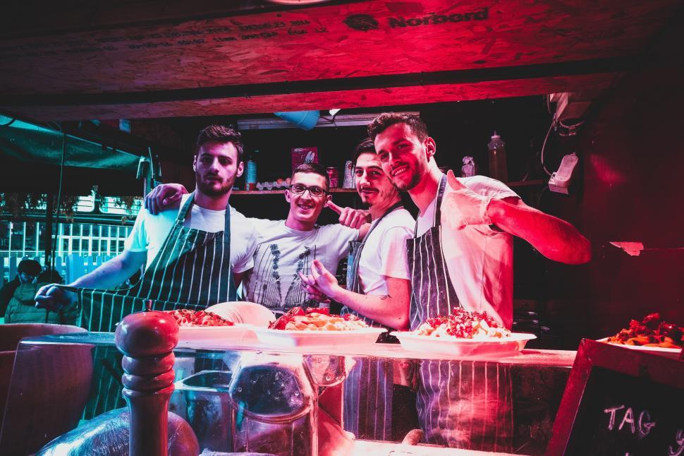 Free Stock Photo of A group of men standing in front of a counter with ...