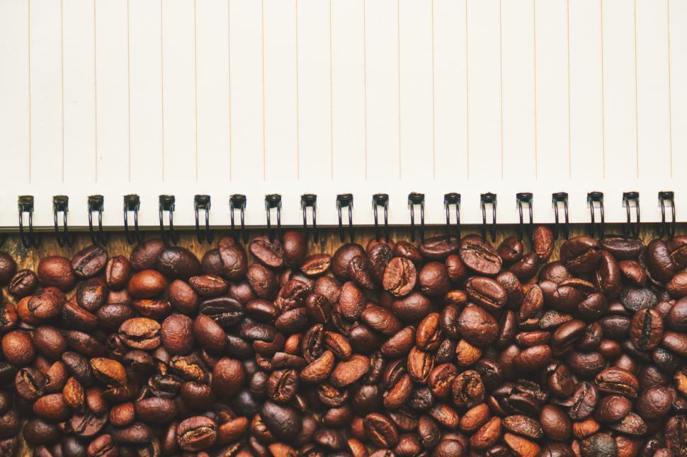 Free Stock Photo of A pile of coffee beans and a spiral notebook ...