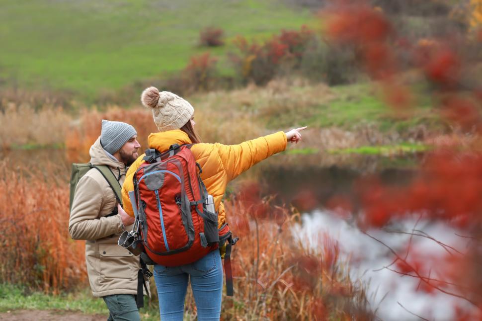 Free Stock Photo of A man and woman with backpacks pointing at ...