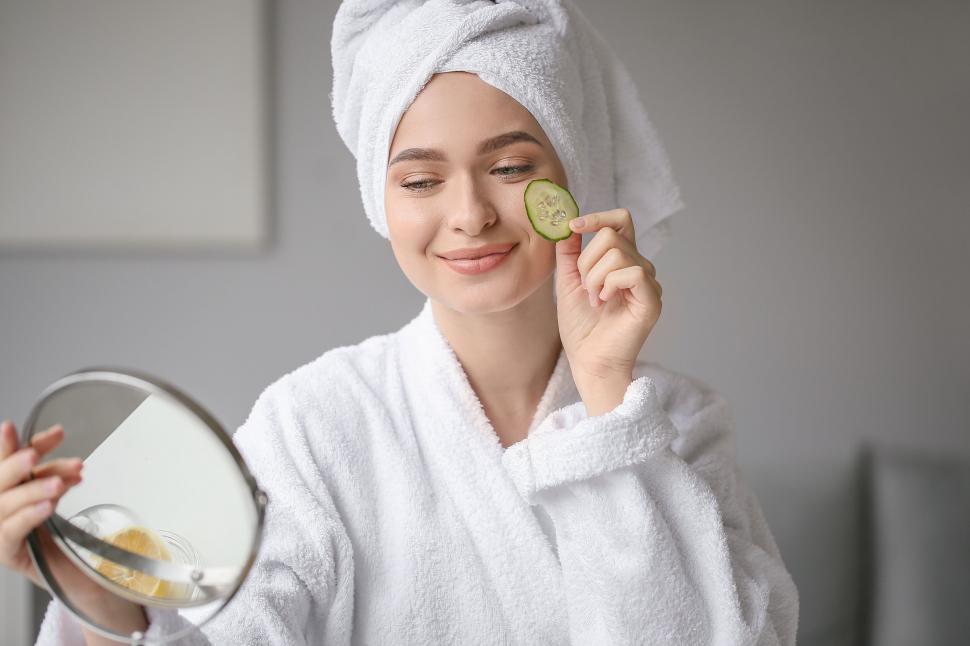 Free Stock Photo of A woman in a white robe holding a slice of cucumber ...