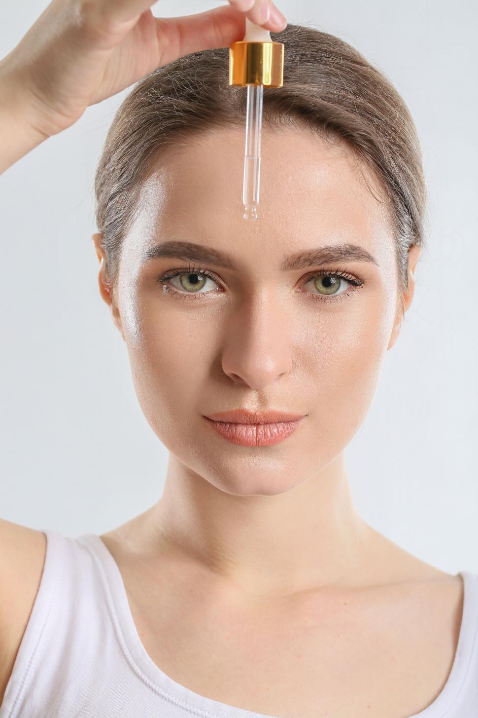 Free Stock Photo of A woman holding a dropper over her forehead ...