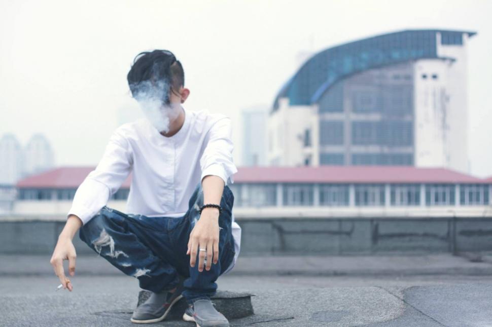 Free Stock Photo of Man squatting with smoke in front of building ...