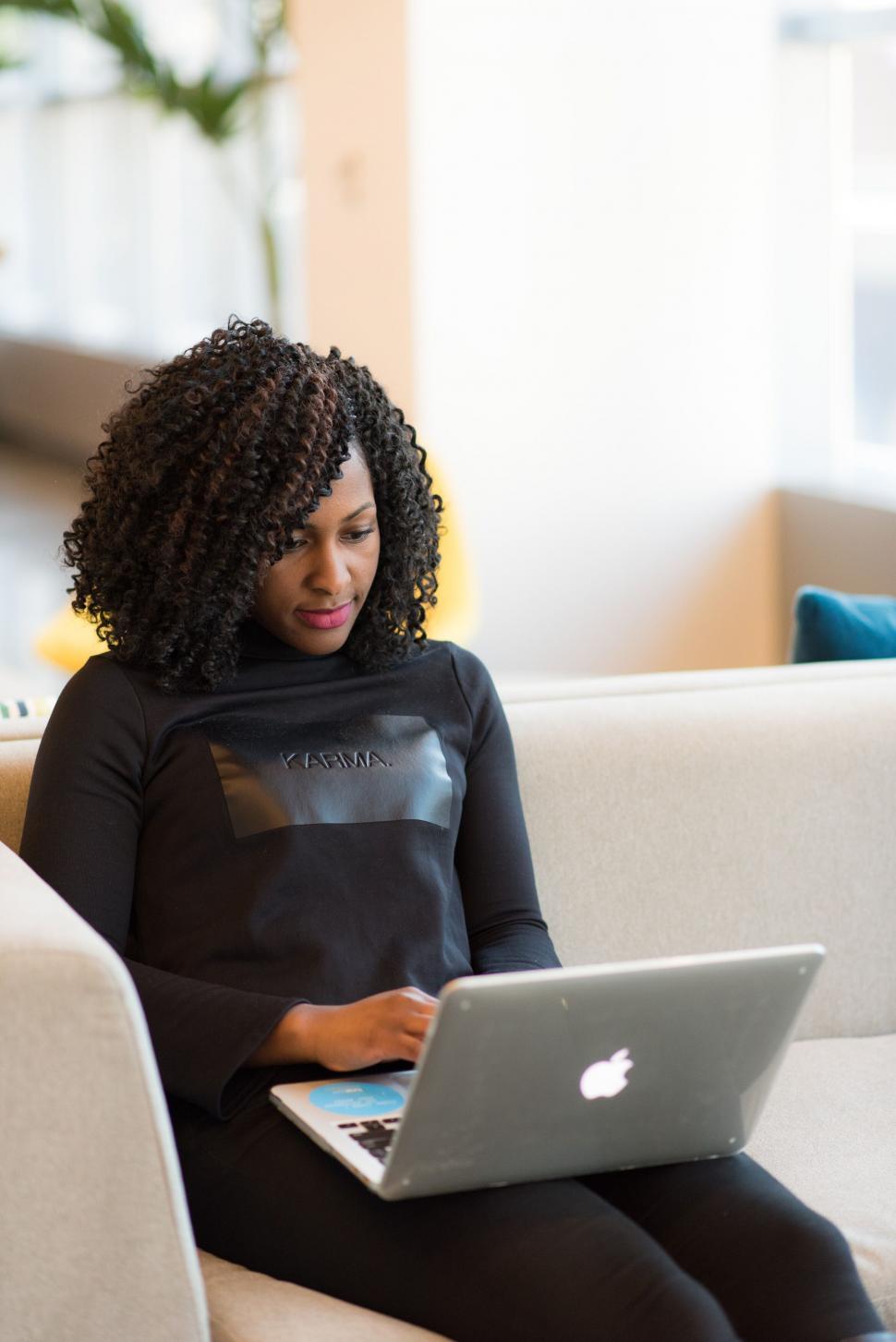 Free Stock Photo of Young woman using a laptop on a modern couch ...