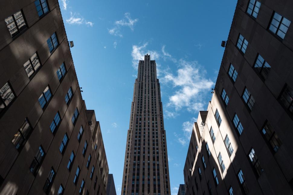 Free Stock Photo of Skyscraper rising between two buildings under blue ...