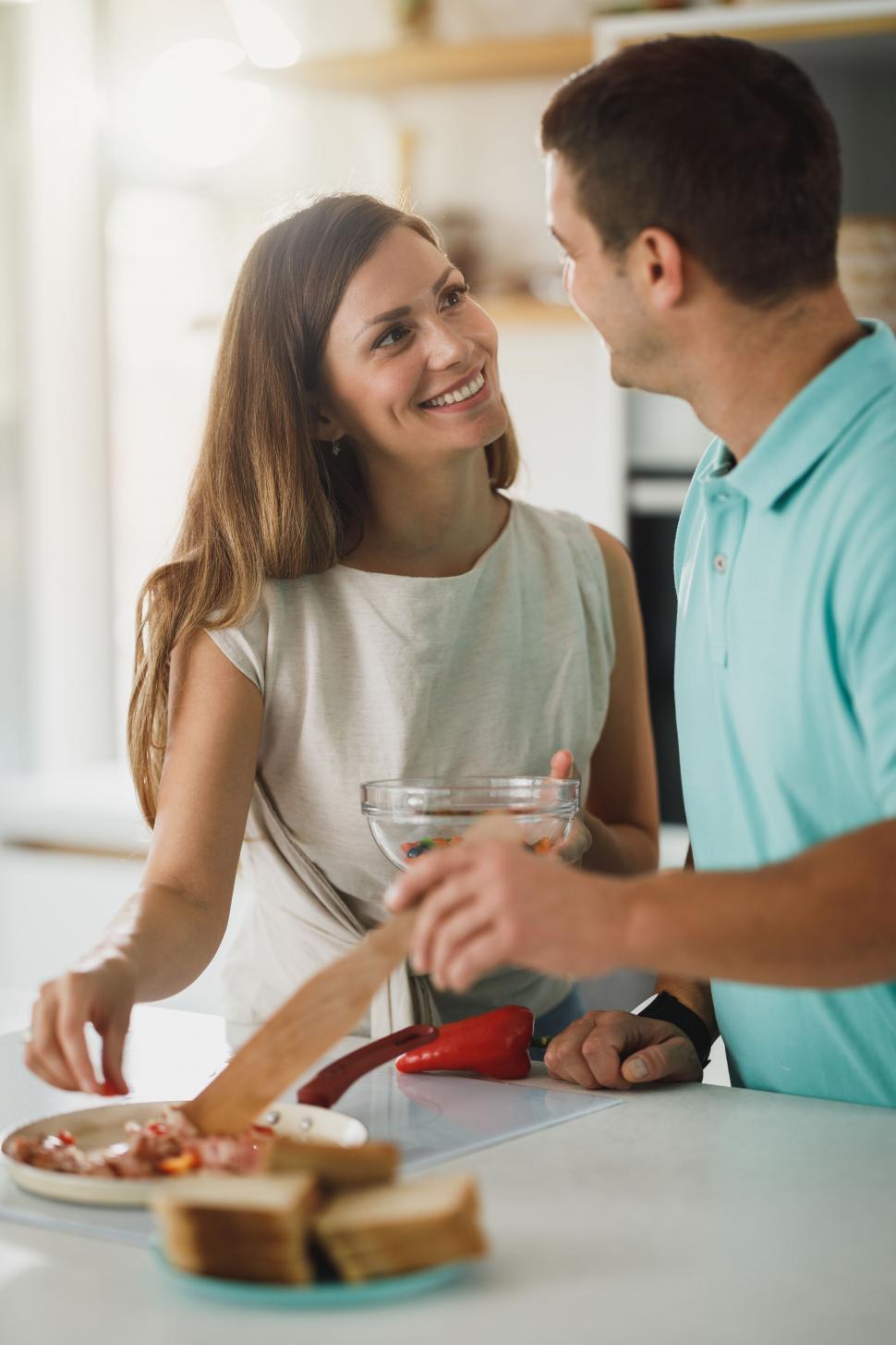Free Stock Photo of Couple smiling while cooking in the kitchen ...