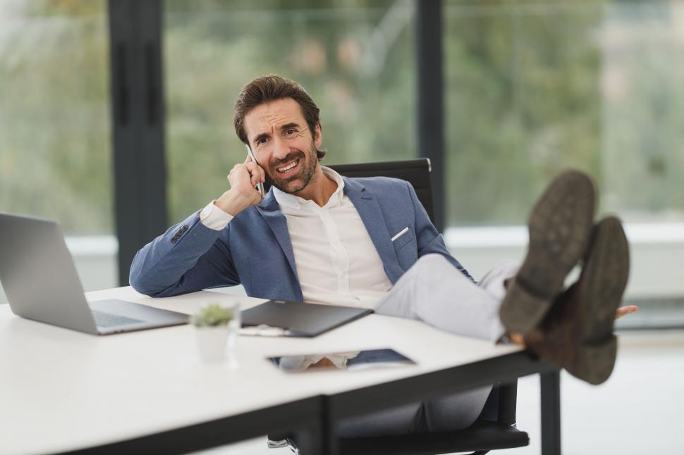 Free Stock Photo of Businessman relaxed on phone at office desk ...