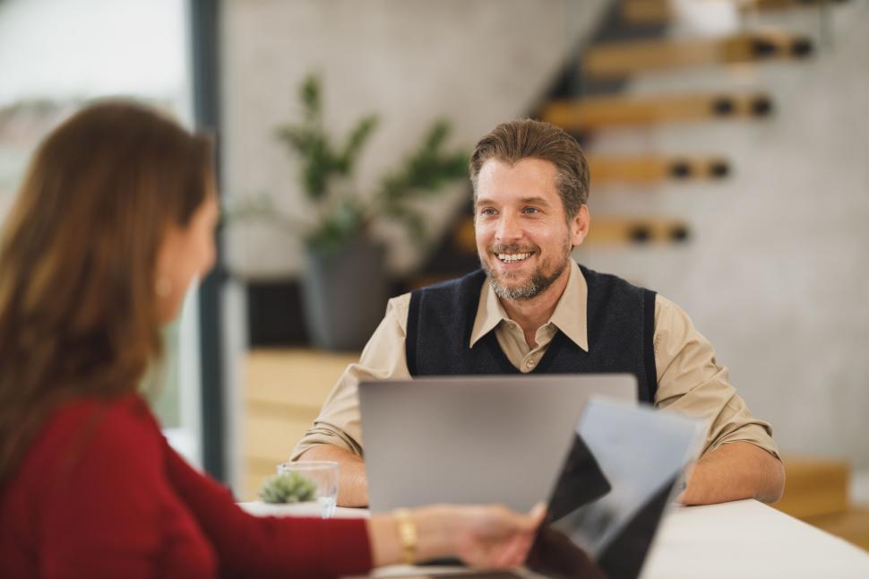 Free Stock Photo of Businessman smiling at colleague over a laptop ...