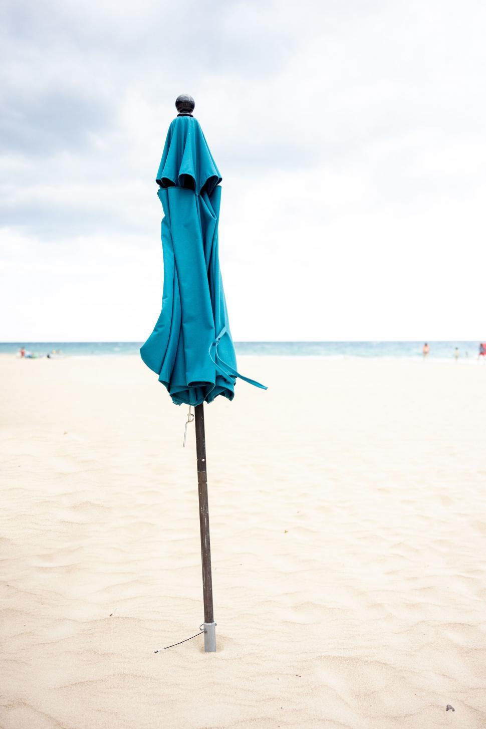 Free Stock Photo of Closed blue beach umbrella on sandy shore ...