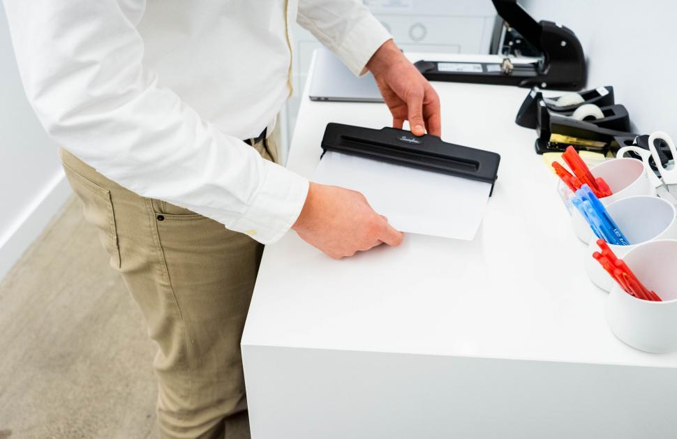Free Stock Photo of Man using a paper binder on a desk | Download Free ...