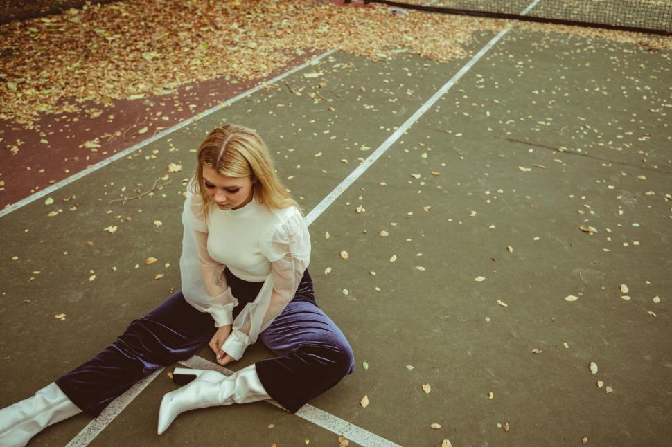 Free Stock Photo of Woman sitting on tennis court with autumn leaves ...