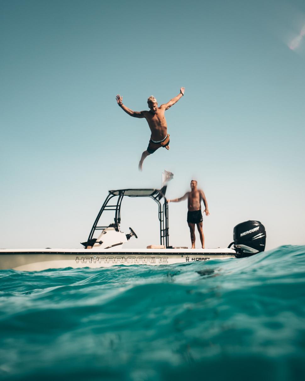 Free Stock Photo of Man jumping off boat into azure waters | Download ...