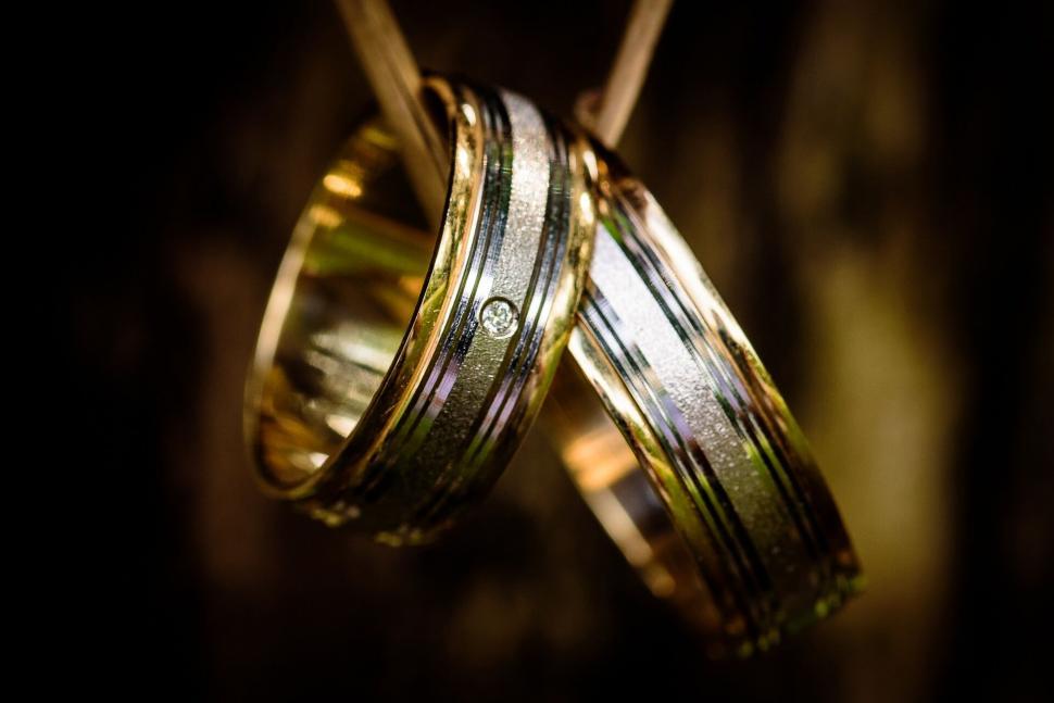 Free Stock Photo of Wedding rings hanging on a reflective surface ...