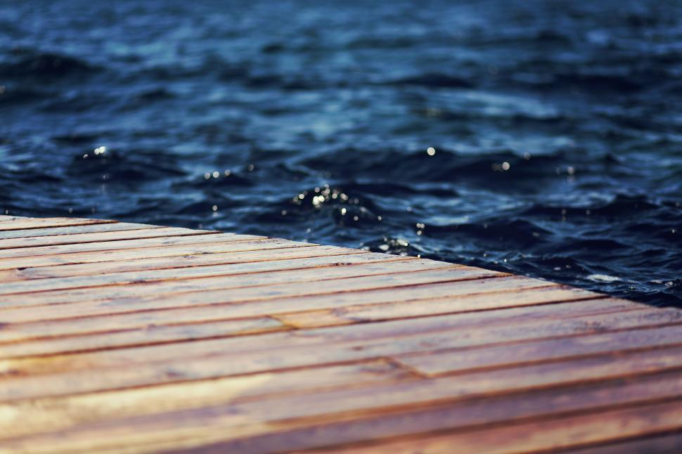Free Stock Photo of Wooden dock extending over the calm, rippling water ...