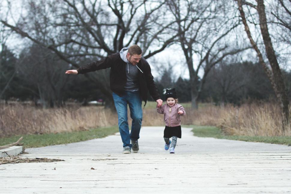 Free Stock Photo of Adult guiding child on a park pathway with bare ...