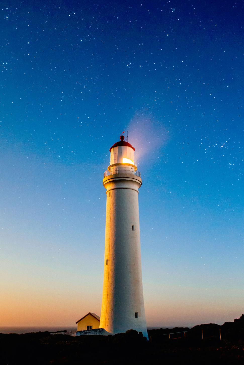 Free Stock Photo of Illuminated lighthouse under a starry night sky ...