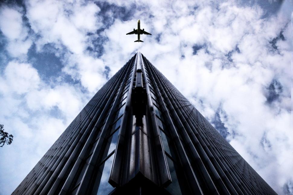 Free Stock Photo of Aeroplane flying over a modern skyscraper with ...