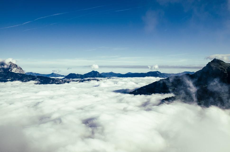 Free Stock Photo of Mountain peaks rise above a cloud-filled landscape with blue sky. | Download ...