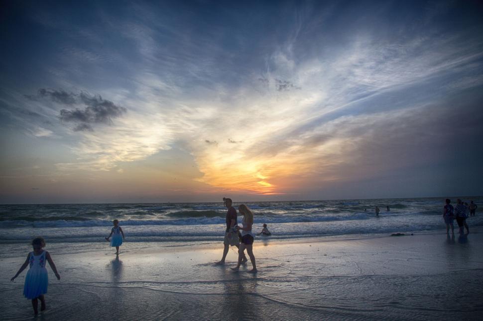 Free Stock Photo of People enjoying a sunset on a sandy beach by the ...