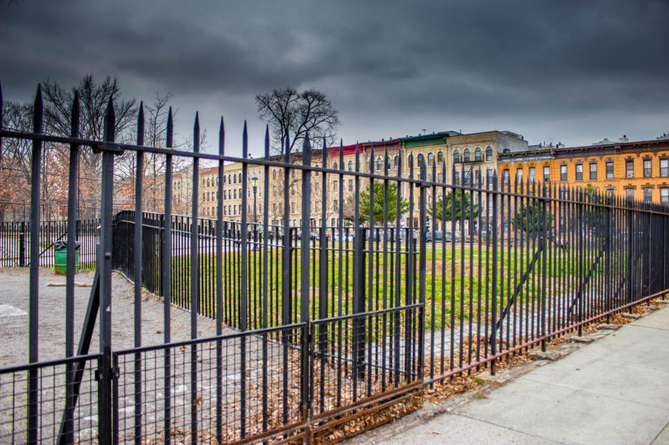 Free Stock Photo of Gated park view with overcast skies and buildings ...