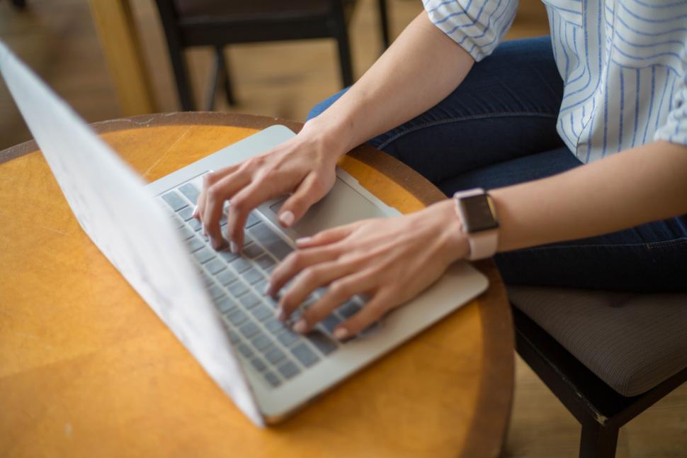 Free Stock Photo of Hands typing on laptop placed on round wooden table ...