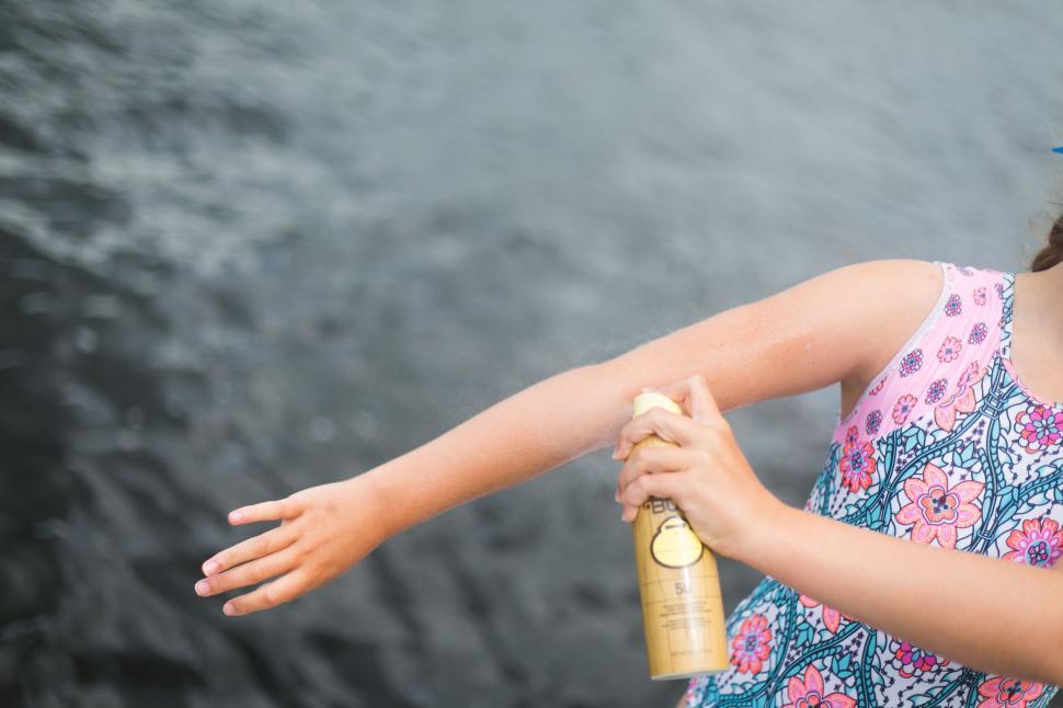Free Stock Photo of Girl sprays her arm with insect repellent near ...