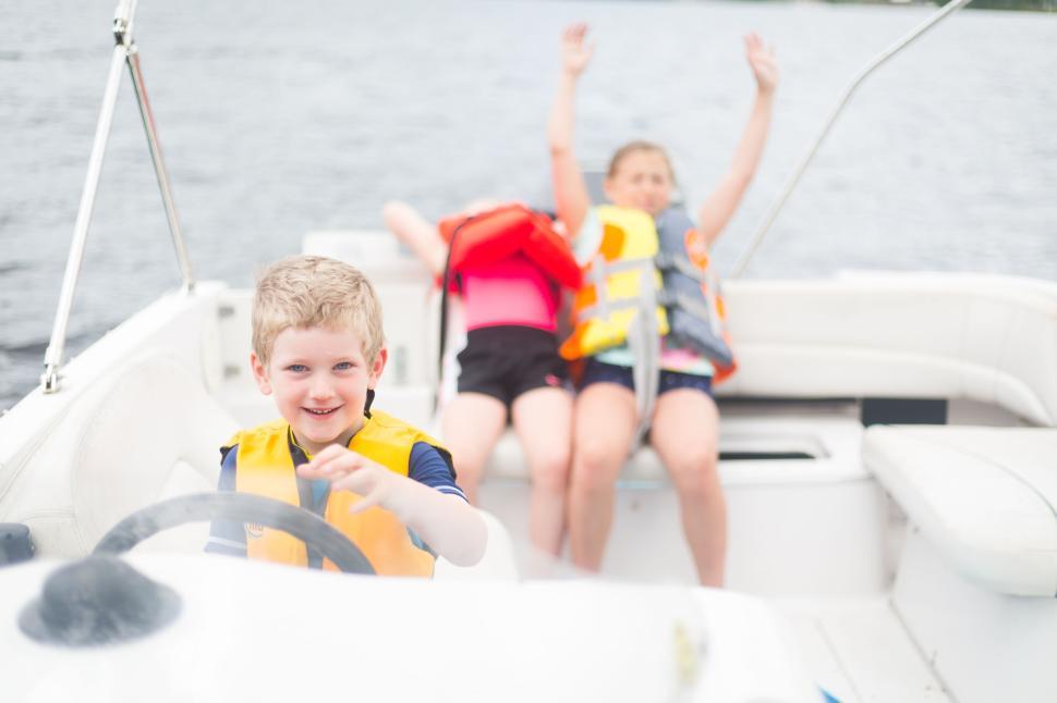 Free Stock Photo of Boy in life jacket steering a boat on a lake, two ...