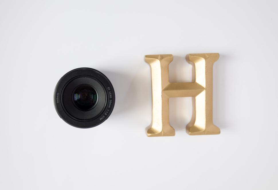 Free Stock Photo of Camera lens and golden H letter on a plain white ...