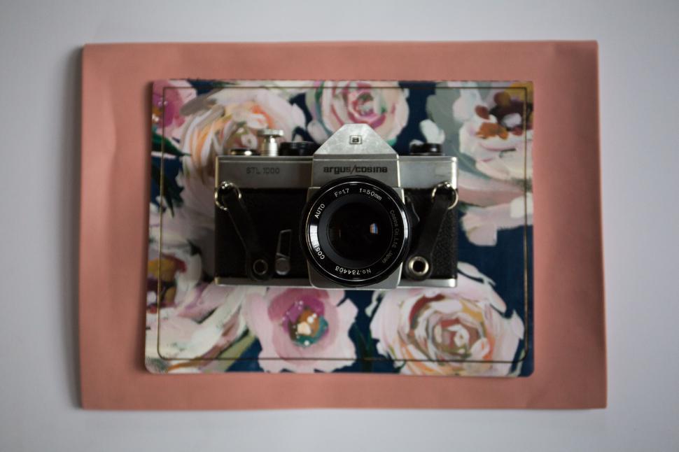 Free Stock Photo of Vintage camera on floral print paper next to a pink ...