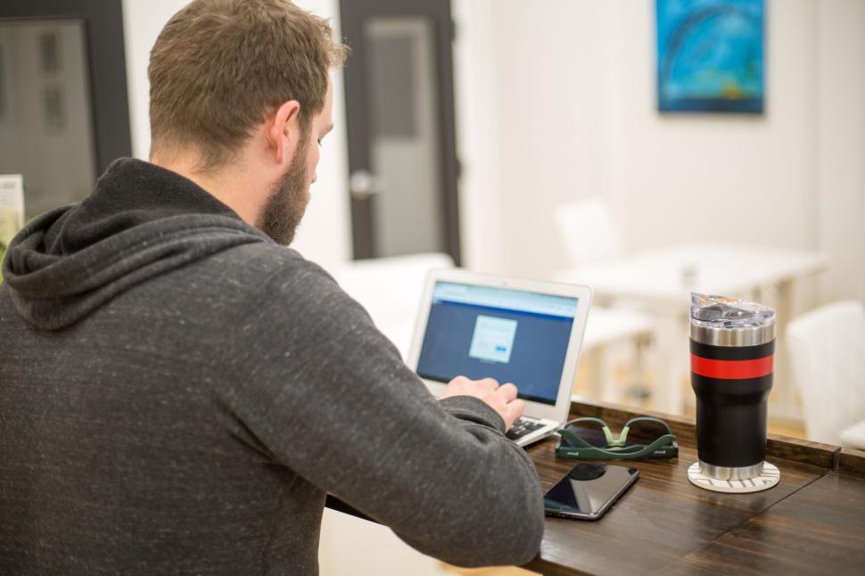 Free Stock Photo of Man working on laptop with drinks and gadgets on ...