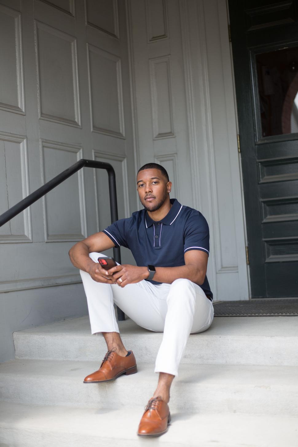 Free Stock Photo of Man in stylish casual attire on steps, holding his ...